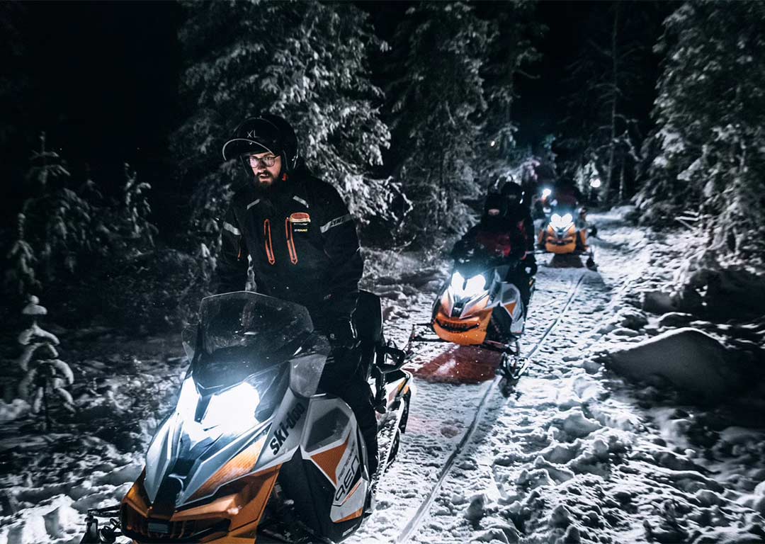 The land of Northern lights, evening snowmobiling in the taiga forest ...